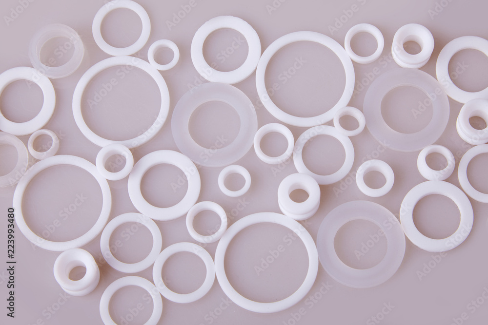 White hydraulic and pneumatic o-ring seals of different sizes scattered ...