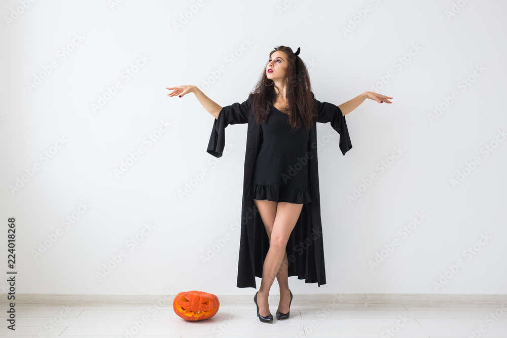 Happy gothic young woman in witch halloween costume smiling over white ...