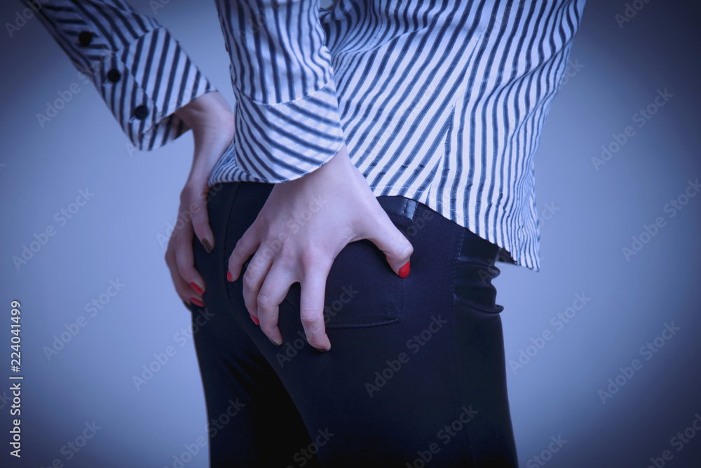 Beautiful sexy business woman holding her hands on ass as symbol of non work and non business ...