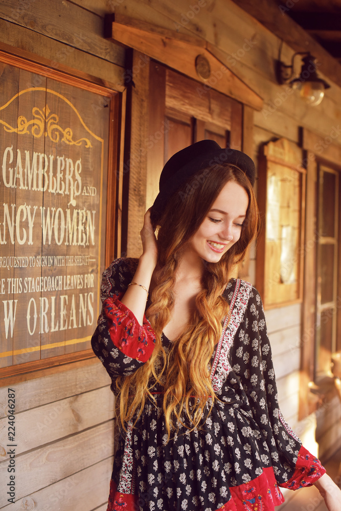 Girl in the Wild West, in Western house. Girl in hat with long cerly ...