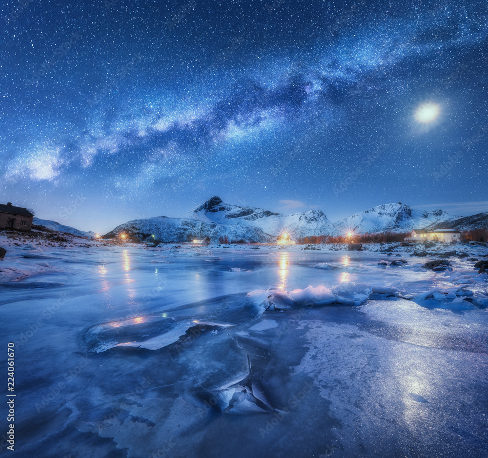 Milky Way above frozen sea coast, snow covered mountains and starry sky ...
