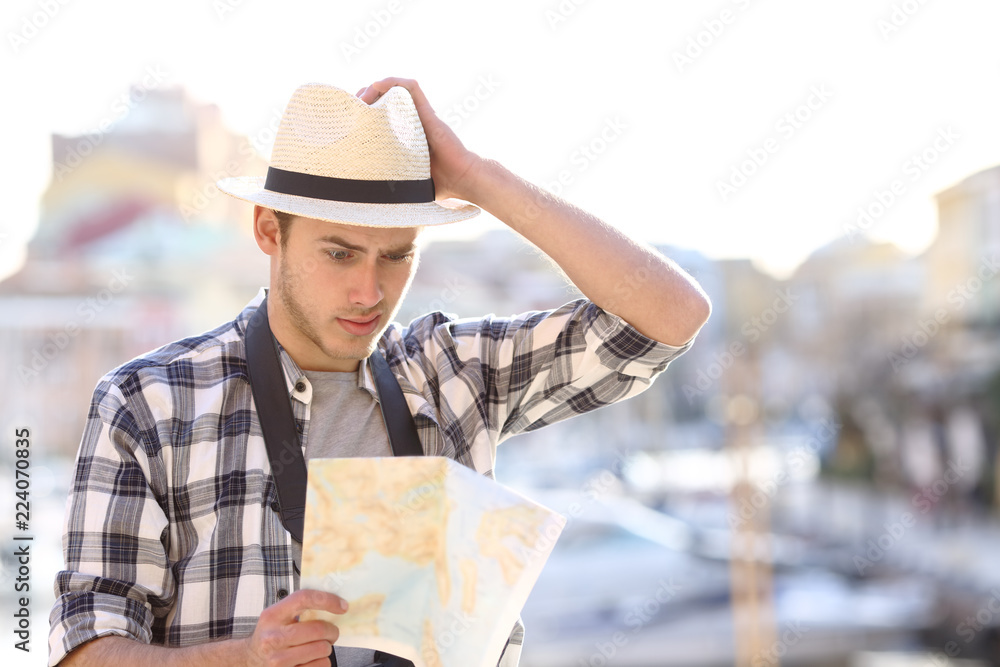 Lost tourist consulting guide in a coast town Stock Photo | Adobe Stock
