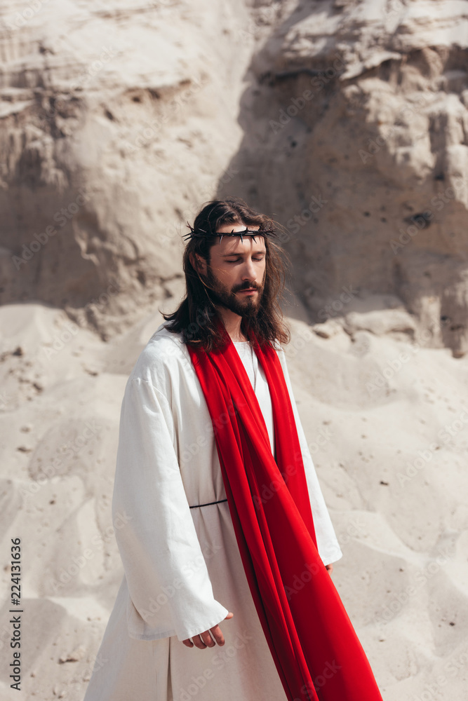 handsome Jesus in robe, red sash and crown of thorns walking with ...