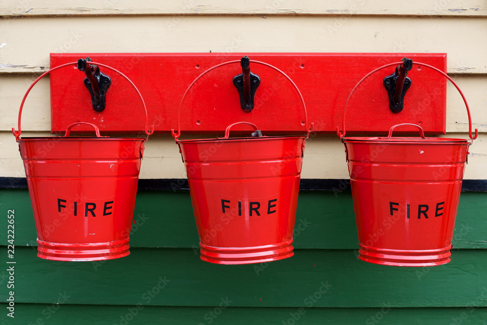 Three red fire buckets mounted on a wall at Pickering Railway Station ...