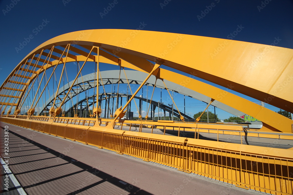 Bright yellow bridge named Hogeweidebrug over the Amsterdam-Rhine canal ...