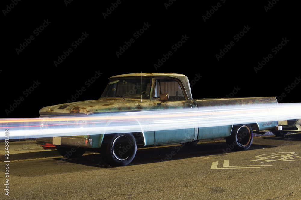 Side view of a vintage classic pick up truck car and light trails ...