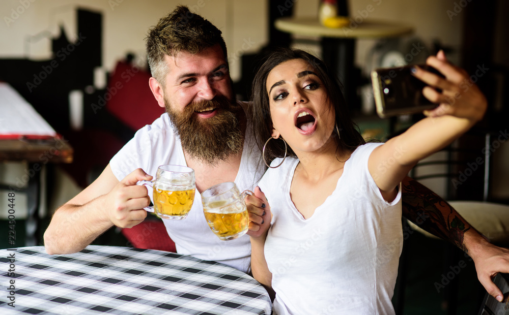 Couple cheerful mood drinking beer in pub. Man bearded hipster and girl ...