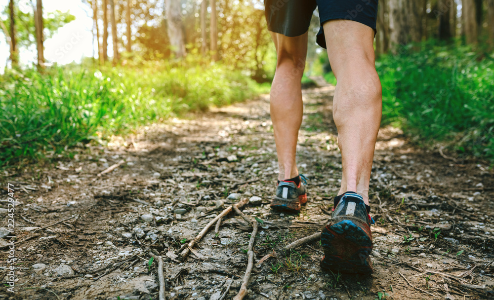 Detail of feet of young man participating in a trail race through the ...