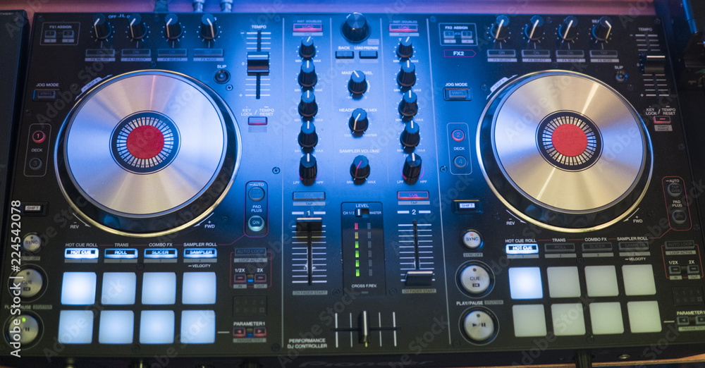 DJ plays and mix music on digital mixer controller. Close-up DJ ...