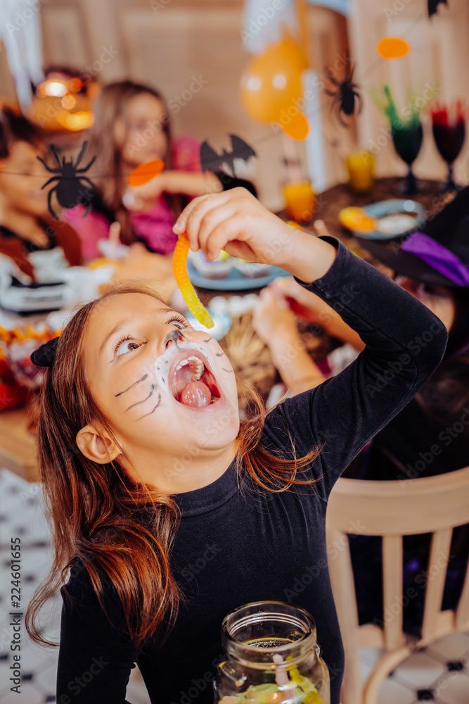 Gummy worm. Dark-haired beautiful cute girl with painted face wearing ...