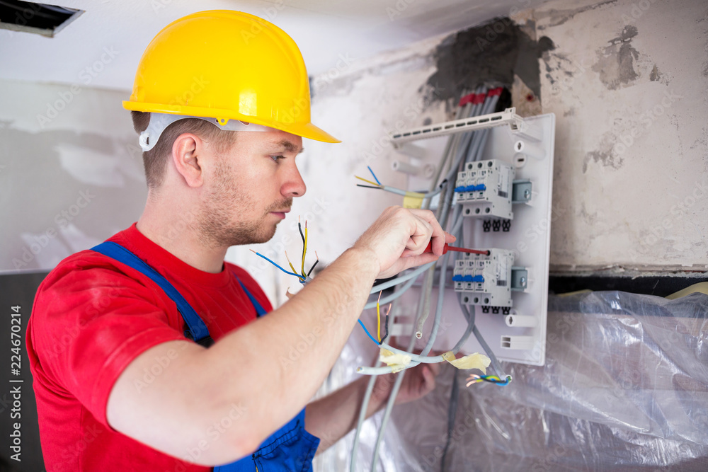Skilled worker mounting automatic switches on distribution board Stock ...