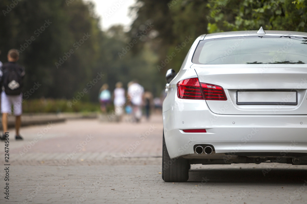 Back view part of white car parked on city pedestrian zone pavement on ...