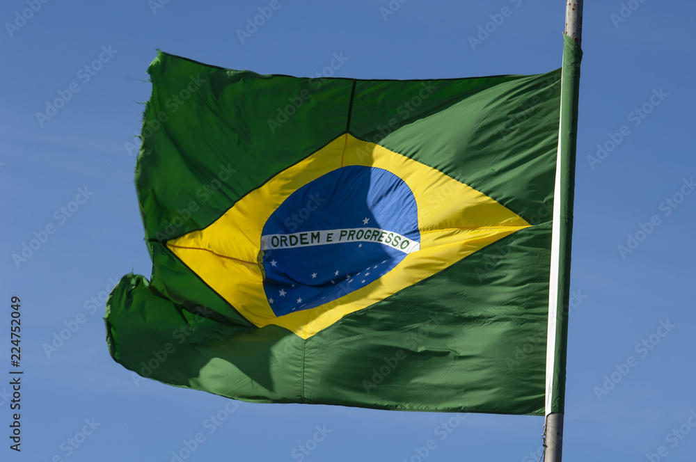 Flag of Brazil fluttering in the wind, old, with ragged edge, in blue ...