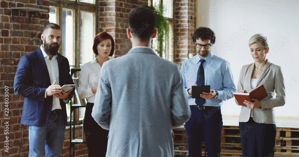 Vidéo Stock Rear of the young boss standing in front of his working ...