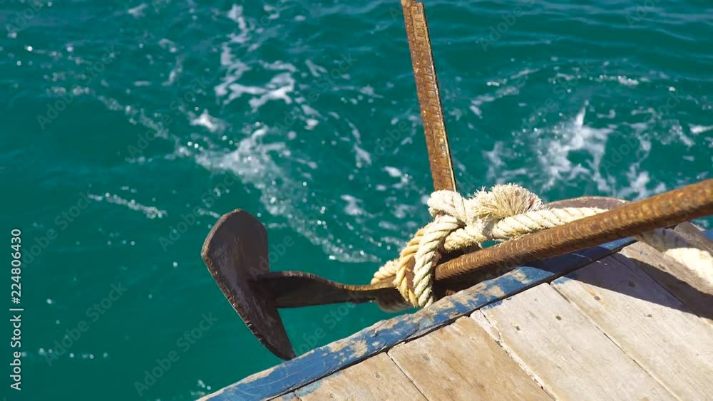 Ship anchor on ship board on turquoise sea water background close up ...