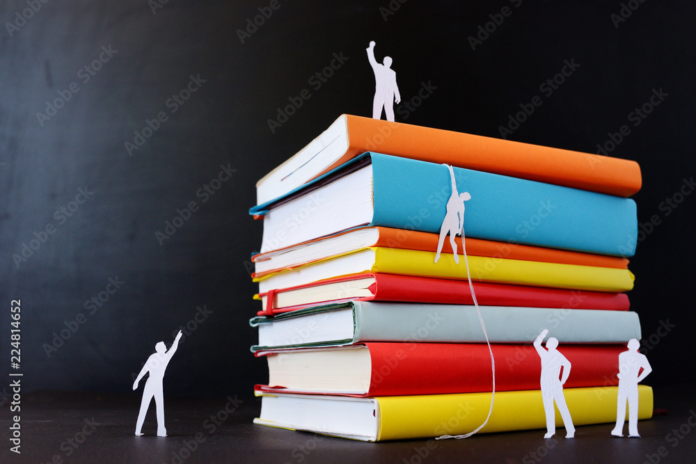 Miniature paper people climb, conquer a stack of books. Stock Photo ...