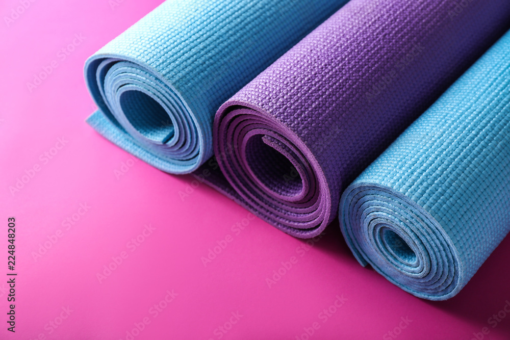 Different yoga mats on color background Stock Photo | Adobe Stock