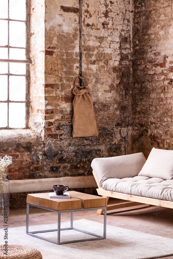 Wooden table in front of grey sofa in living room interior with red ...