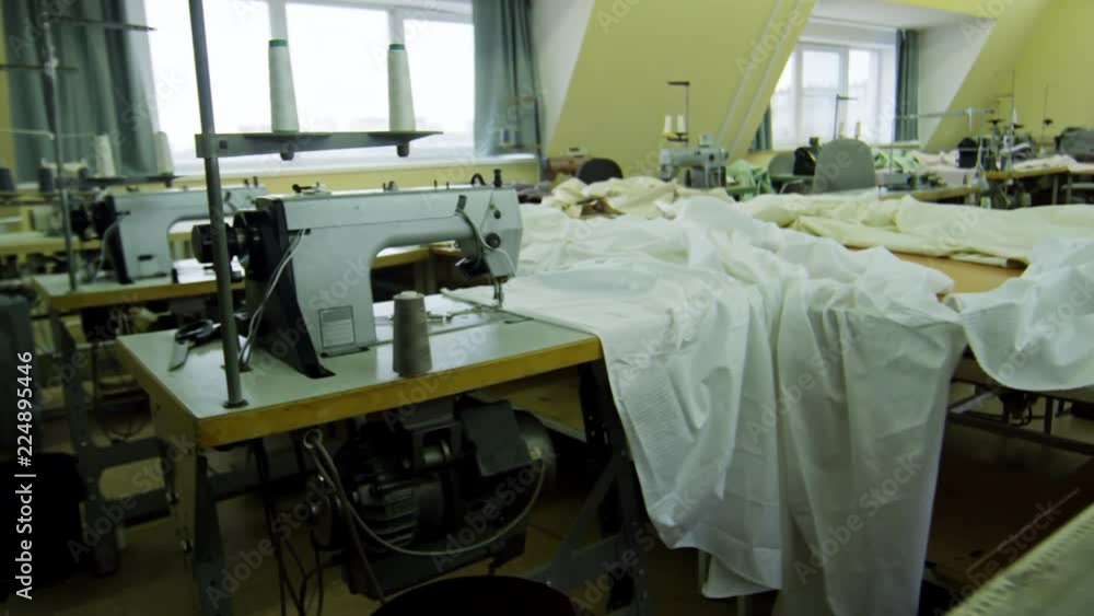Dolly shot of empty tailoring shop with sewing machines, tools and ...