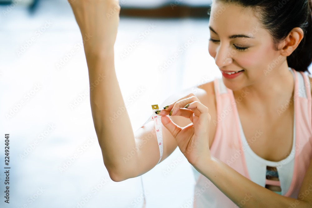 Asia women in fitness uniform And it is using Measure the arm. to see ...