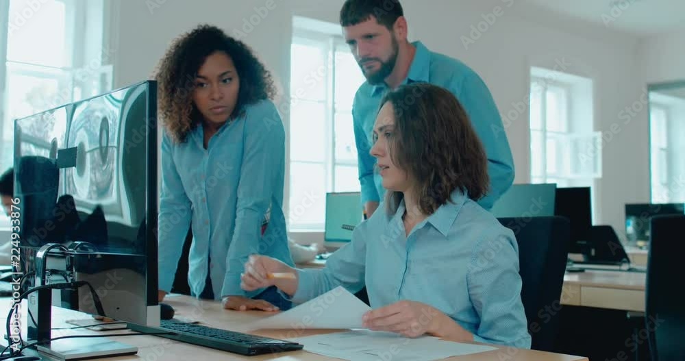 Multi racial team of three office workers communicating together and ...