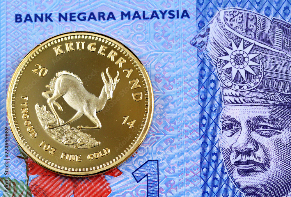 A close up image of a gold South African Krugerrand with a blue ...