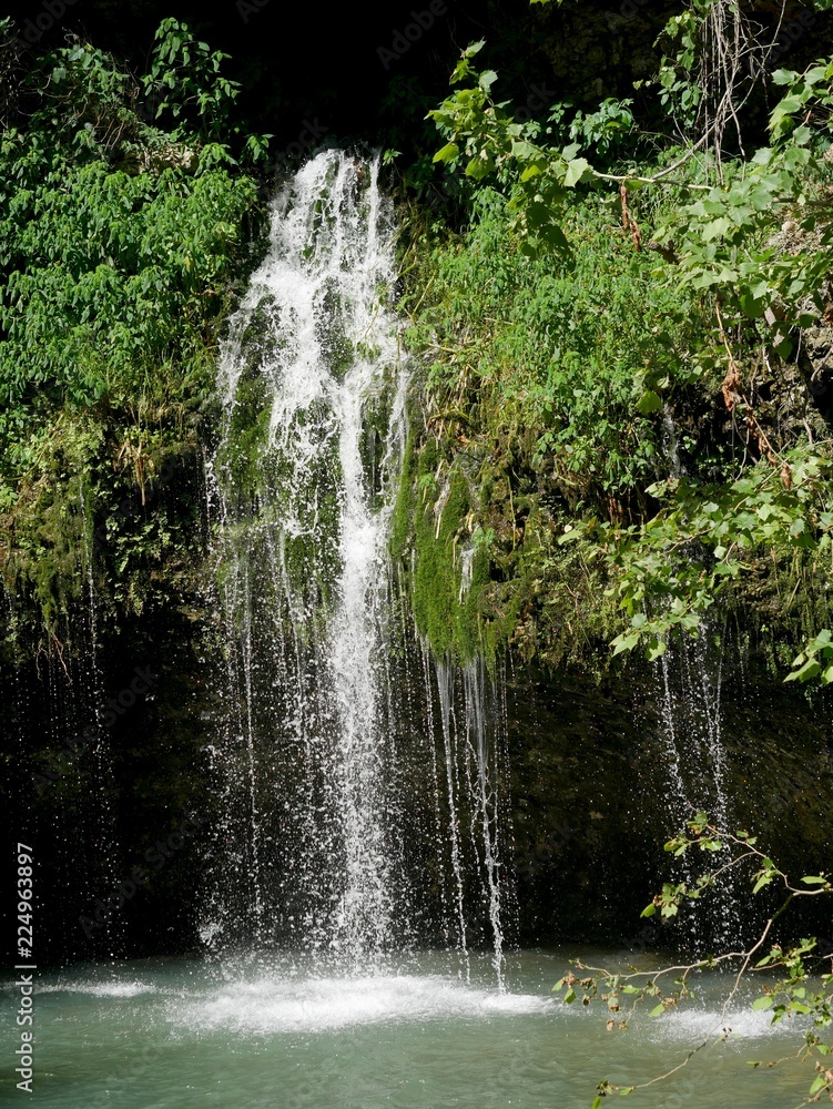 Natural falls in the mountains. Curtains of dripping water from a small ...