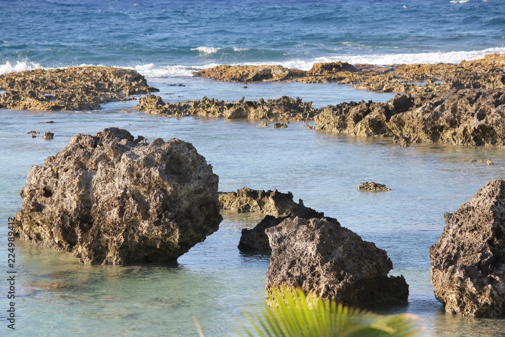 Sharp rocks and corals jutting out of the pristine beaches of Rota ...