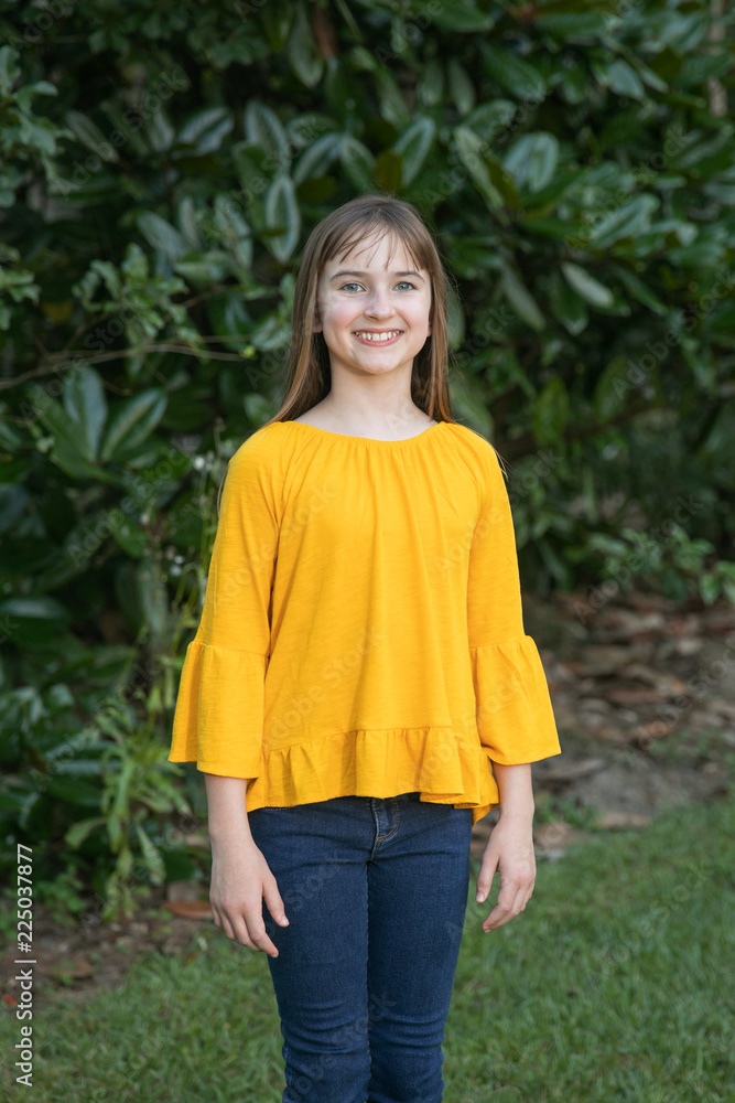 Tween Girl in Yellow Gold Outside in Greenery Stock Photo | Adobe Stock