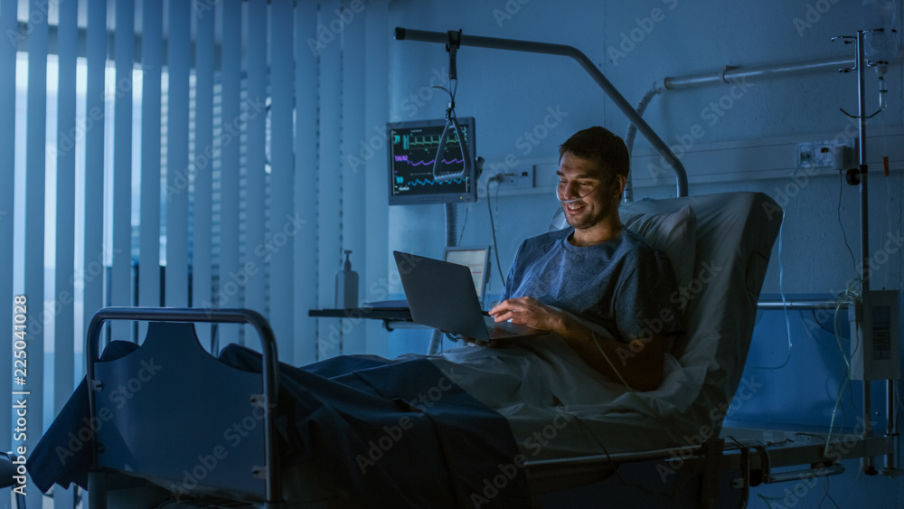 In the Hospital, Recovering Male Patient Uses Laptop while Lying on the ...