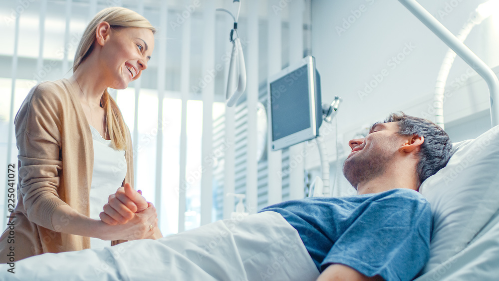 In The Hospital Happy Wife Visits Her Recovering Husband Who Is Lying