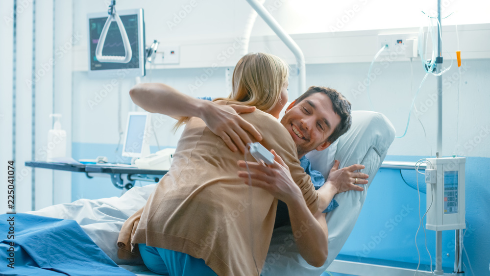 In The Hospital Happy Wife Visits Her Recovering Husband Who Is Lying