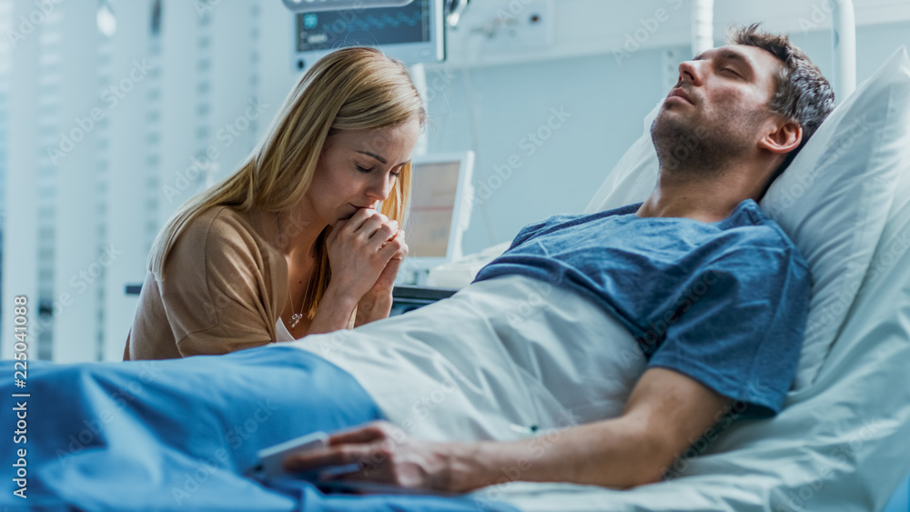 In the Hospital Sick Man Lying on the Bed, His Visiting Wife Hopefully ...