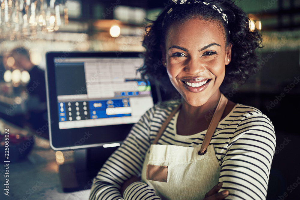 Smiling African waitress standing by a point of sale terminal Stock ...