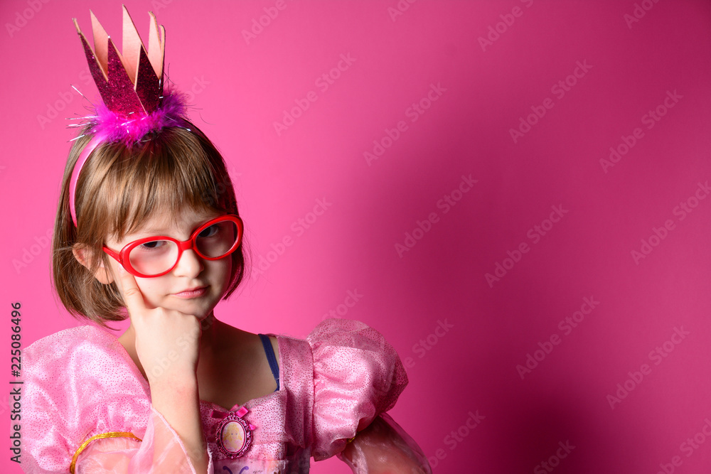 A girl in Princess costume with a crown on her head is thinking how to ...