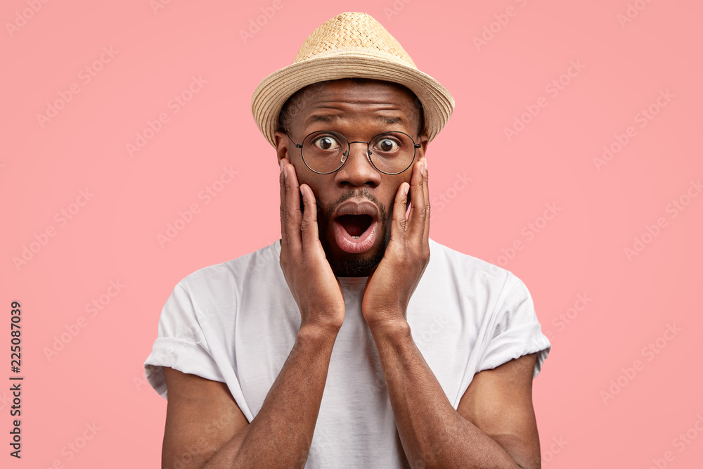 Shocked dark skinned adult man opens mouth with surprisement, gasps ...