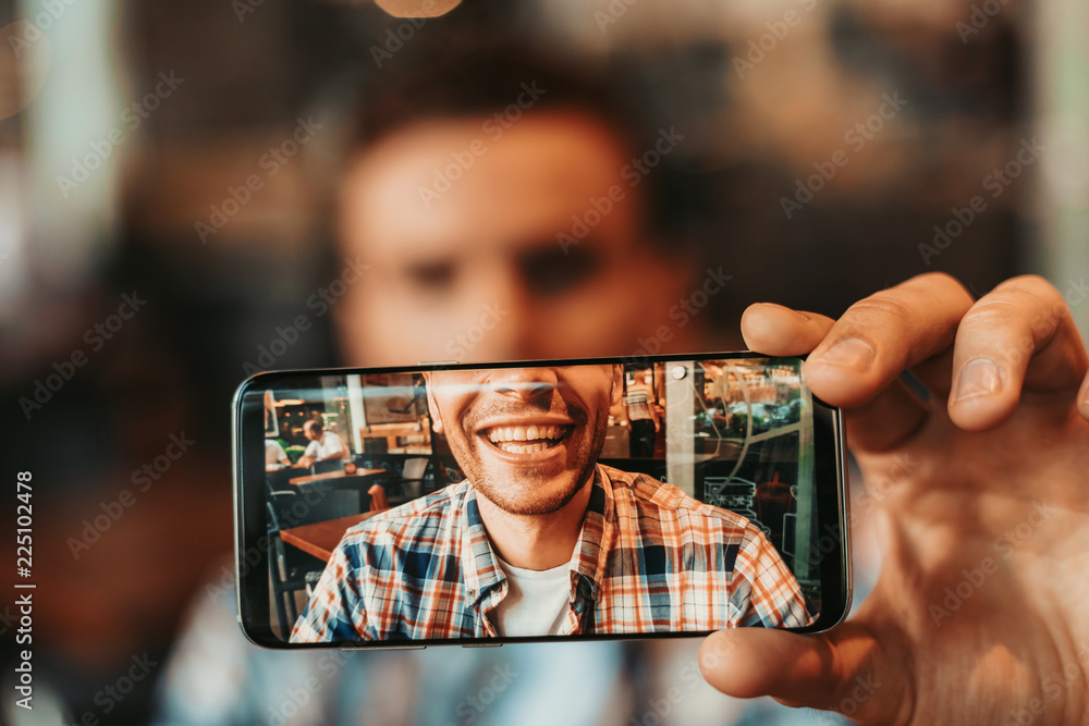 Close up male hand demonstrating screen of phone with picture of dude ...