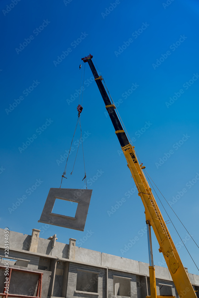 Construction site crane is lifting a precast concrete wall panel. Stock ...