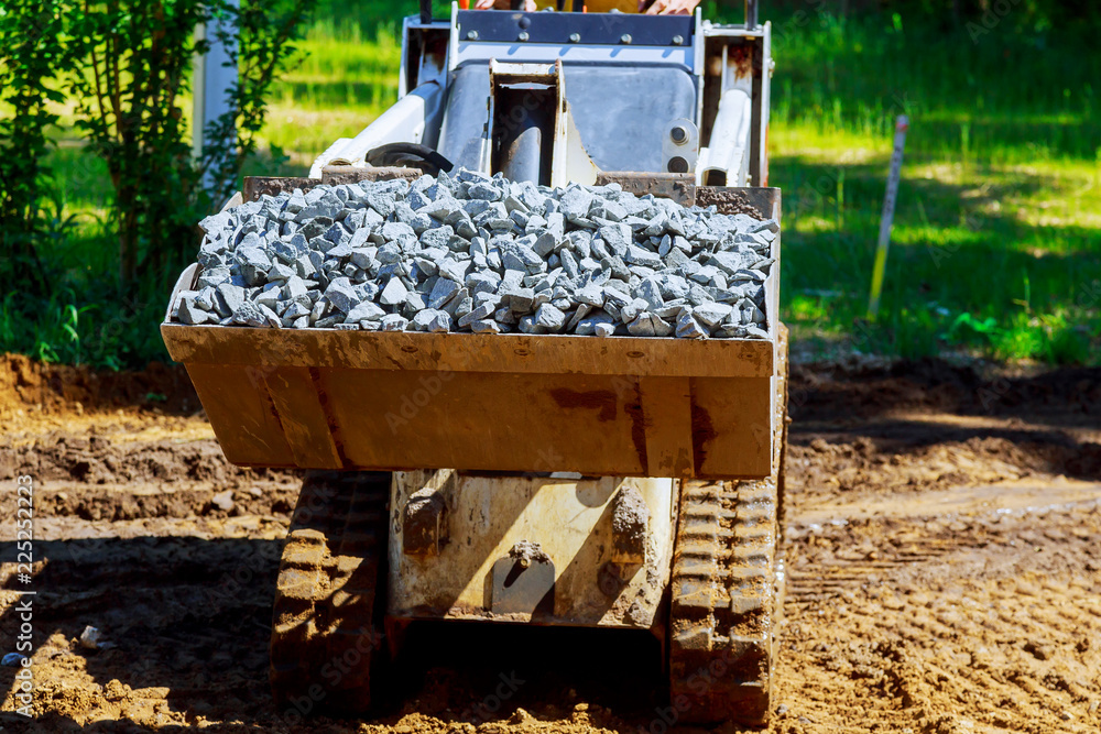 Loader moving with uploaded bucket with stone gravel during ...
