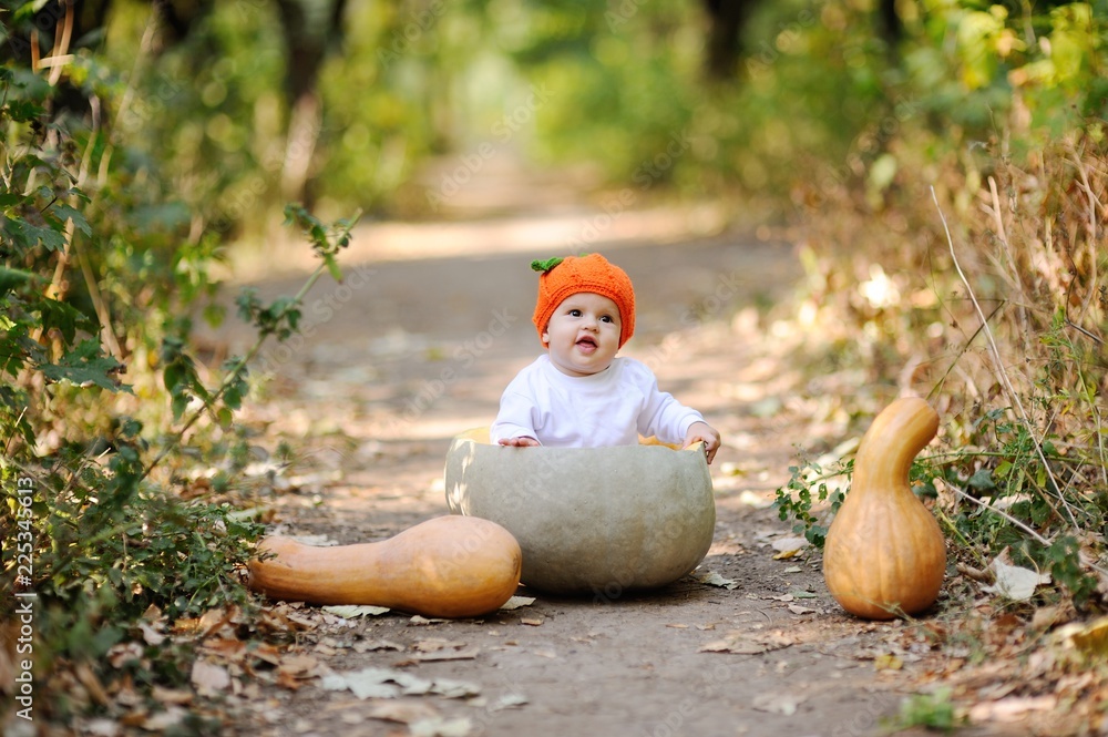 baby girl in the orange cap in the form of a pumpkin sitting inside a ...
