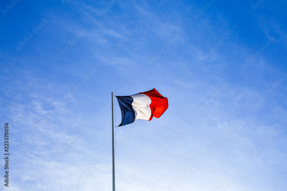 French flag waving the wind in Paris. Clear blue sky background. France ...