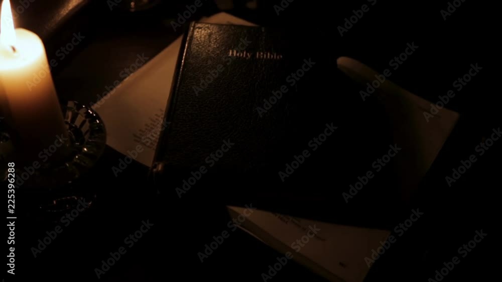 Above Shot of Holy Bible Lit by Candle Light in a Hidden, Dark Place ...