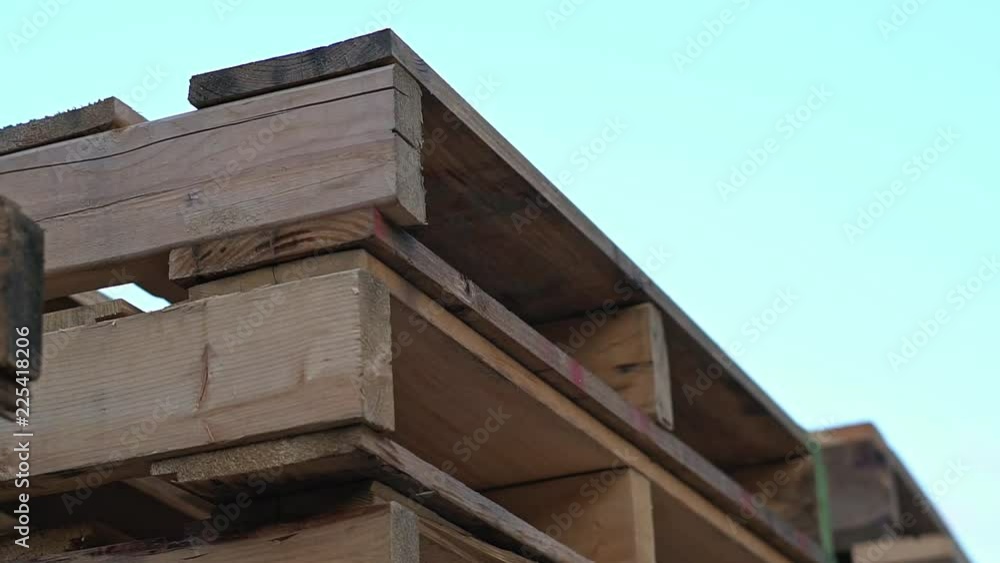 Stacked wooden skids outside of a factory. Slow motion, and shot ...
