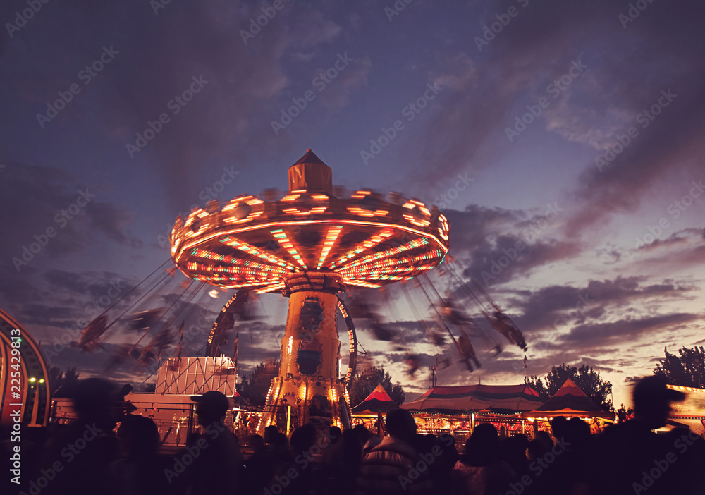 long exposure of a swing ride at a state fair at twilight toned with a ...