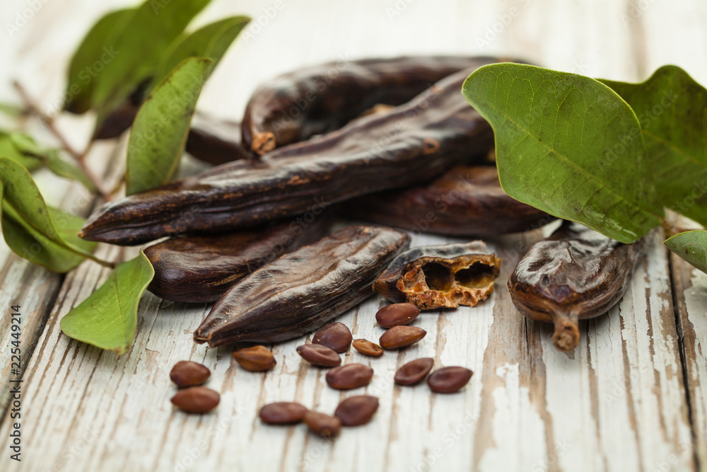 Carob beans. Healthy organic sweet carob pods with seeds and leaves on ...