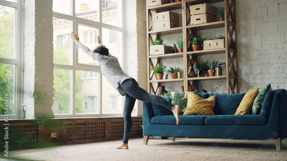 Female yoga instructor is practising alone at home doing complex of ...