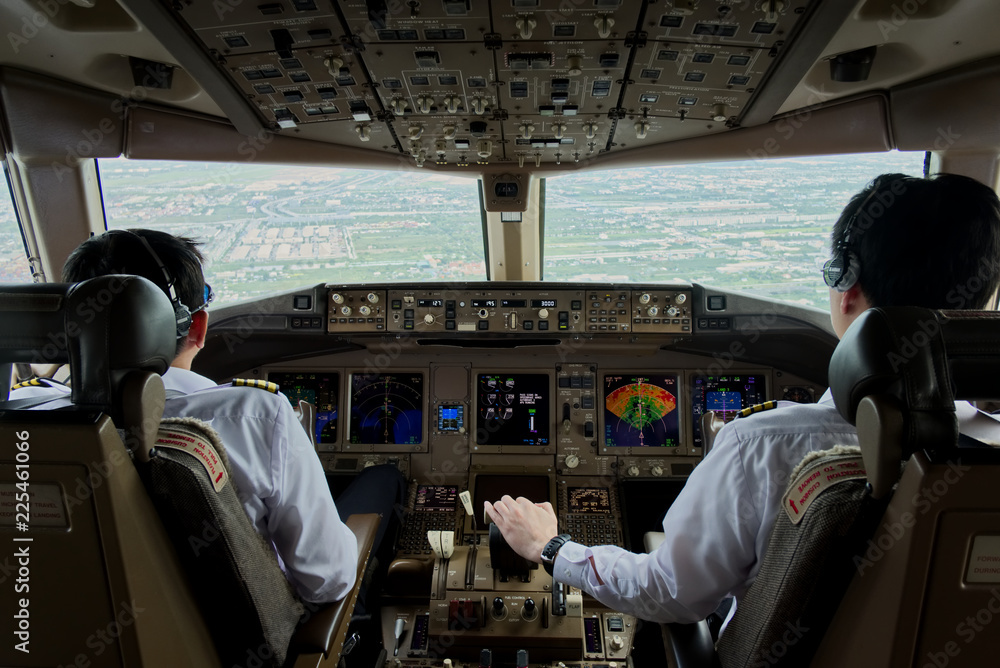 Two airliner pilots are controlling the airplane towards the runway ...