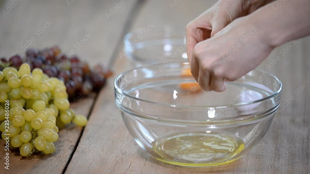 Vidéo Stock Woman hands breaking an egg to separate egg white and yolks ...