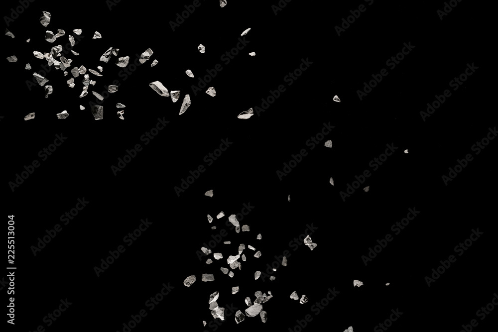 Split debris of stone exploding against black background. Stock Photo ...