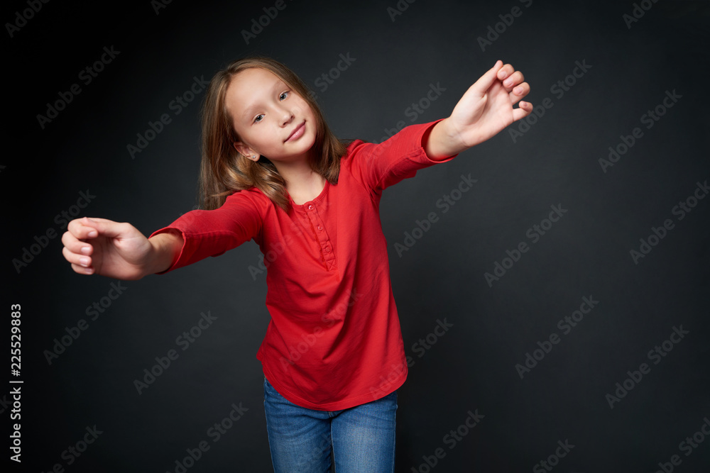 School age girl stretching arms holding imaginary banner copy space ...